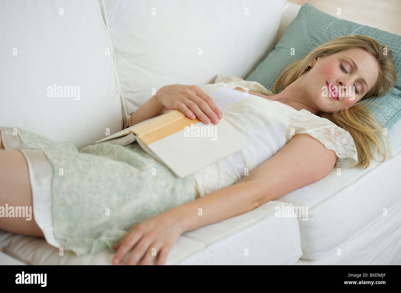 Woman resting on couch Stock Photo - Alamy