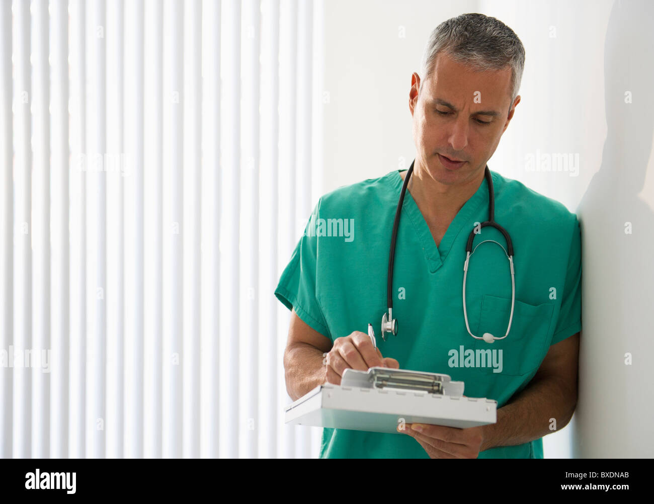 Healthcare worker writing on medical chart Stock Photo - Alamy