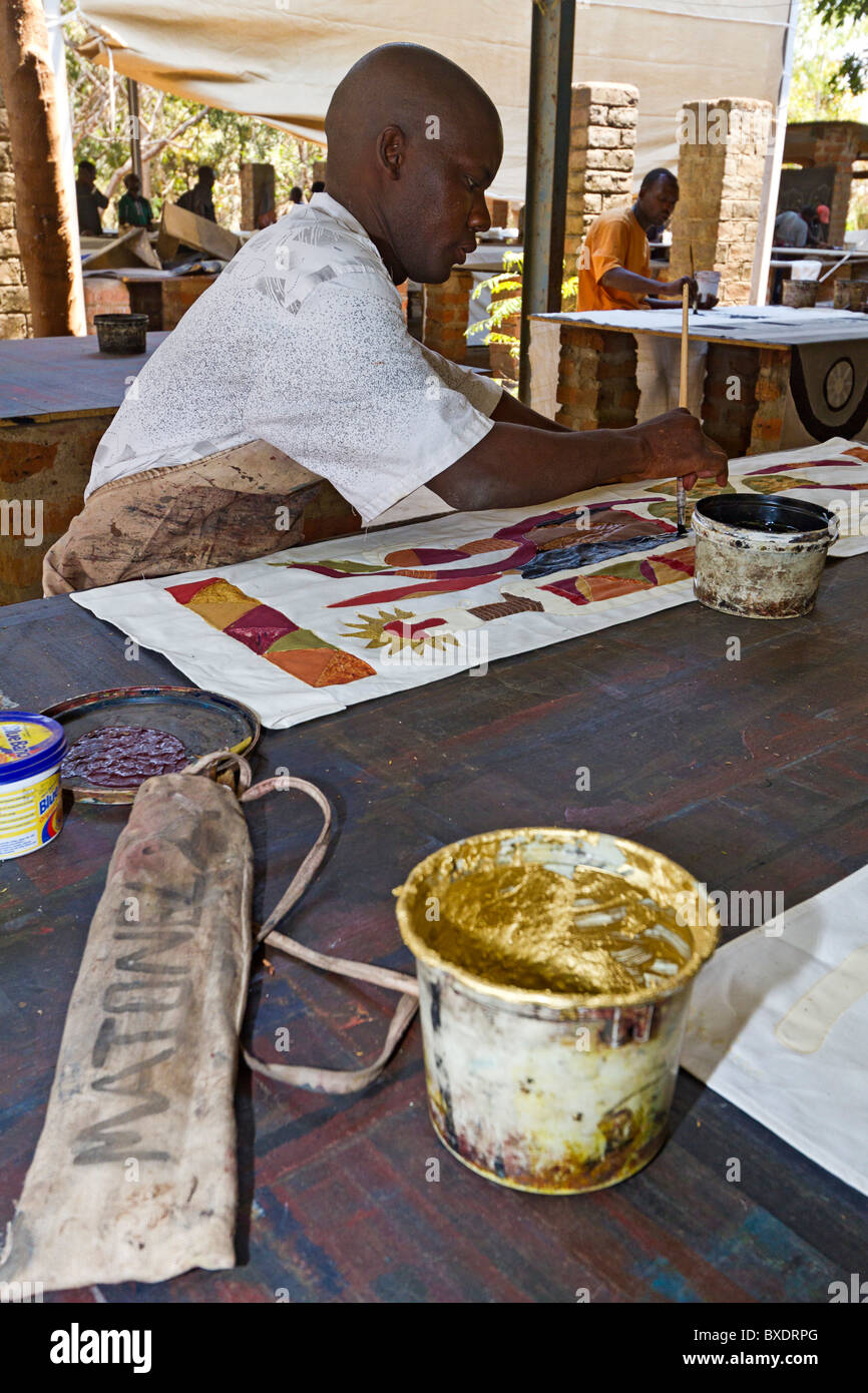 Man paints African pattern onto cloth at Tribal Textiles, a workshop in ...