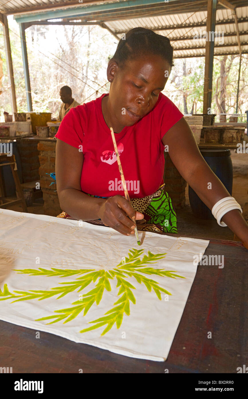 Woman paints African pattern onto cloth at Tribal Textiles, a workshop ...