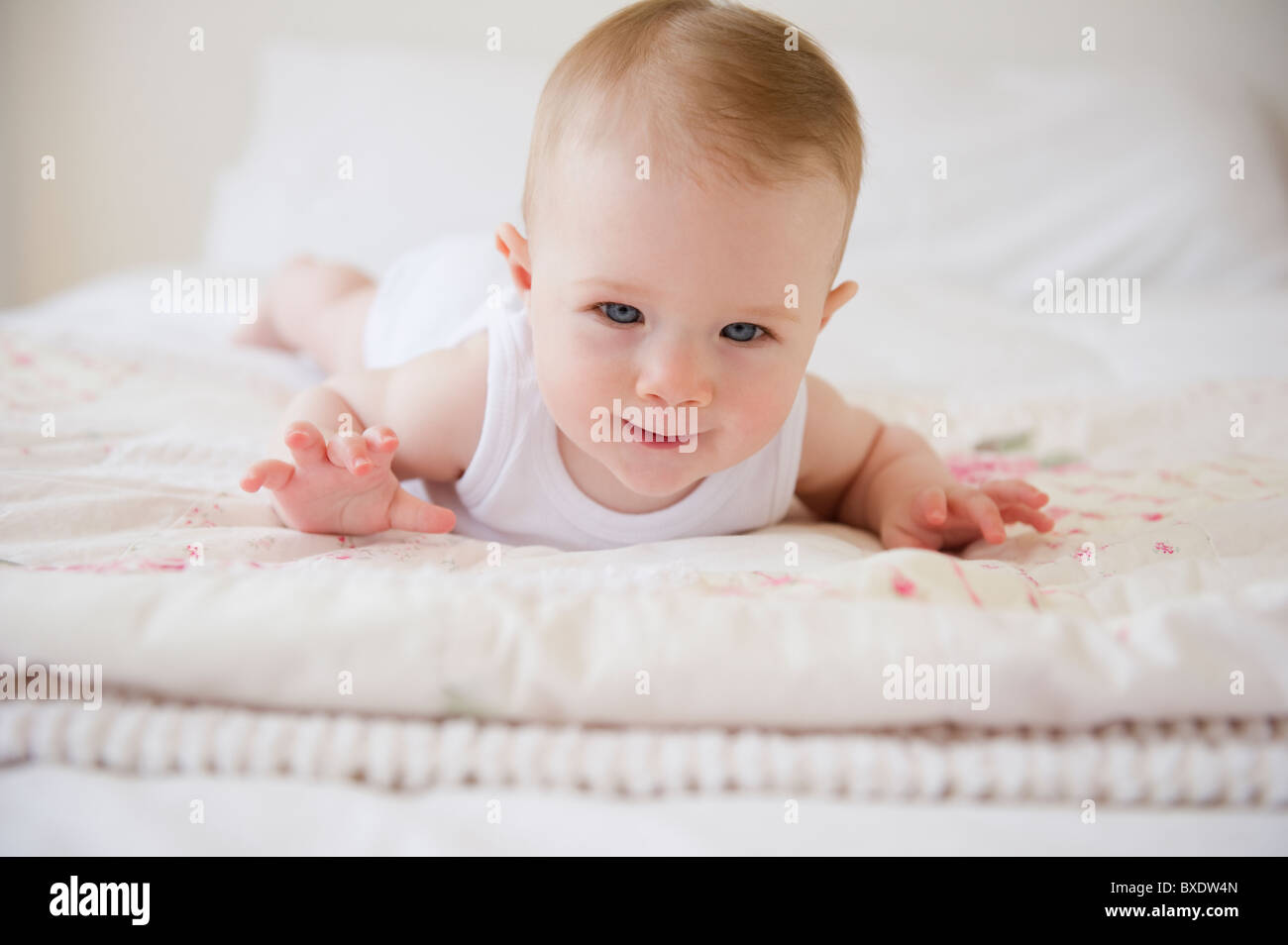 Baby lying on bed Stock Photo - Alamy
