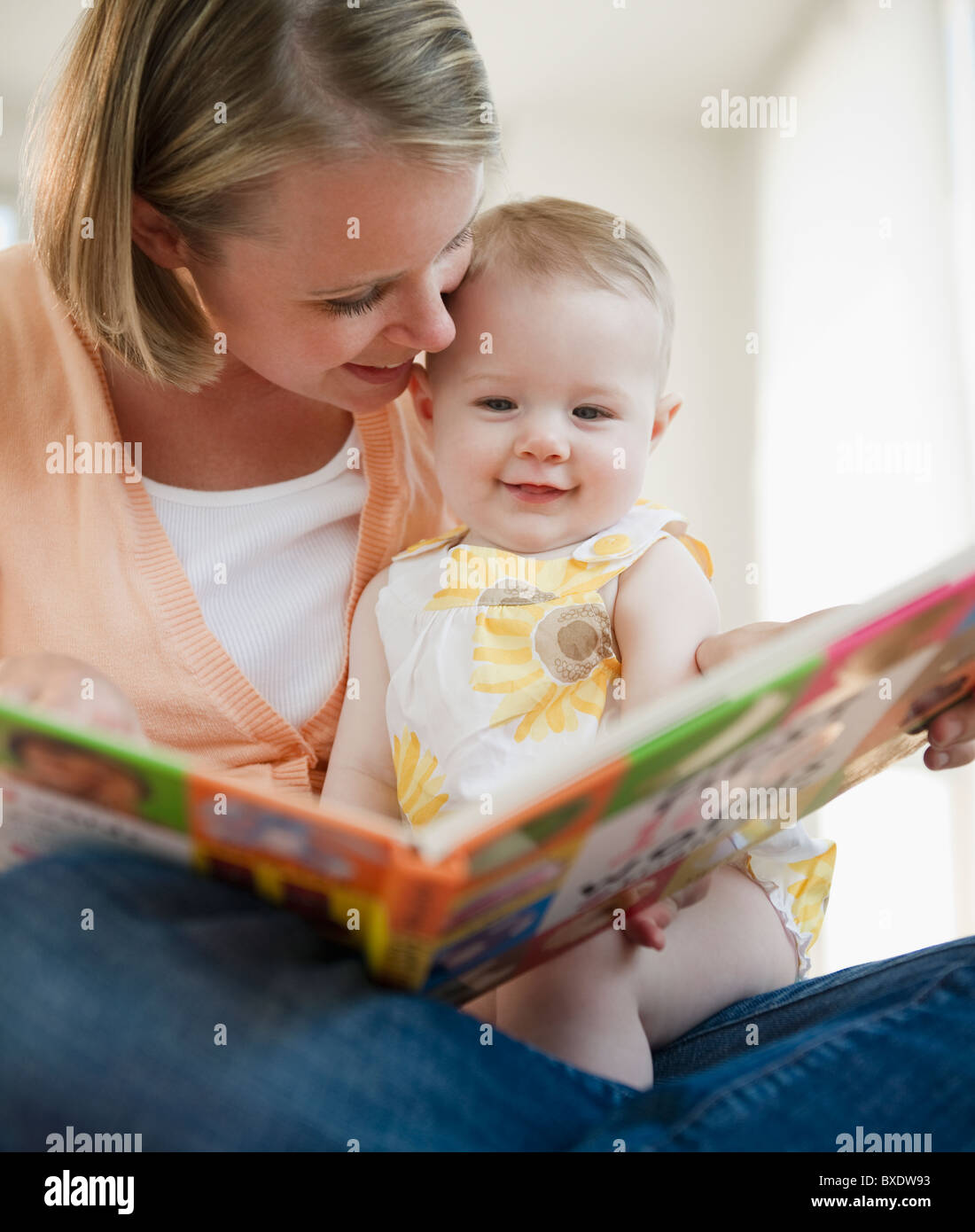 Mother reading book to her baby daughter Stock Photo - Alamy