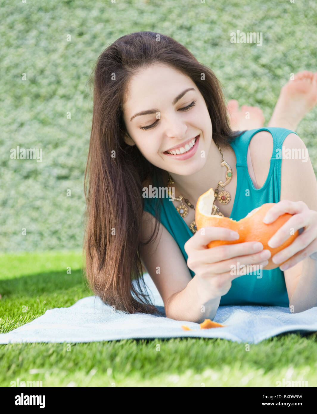 Young woman peeling an orange Stock Photo - Alamy