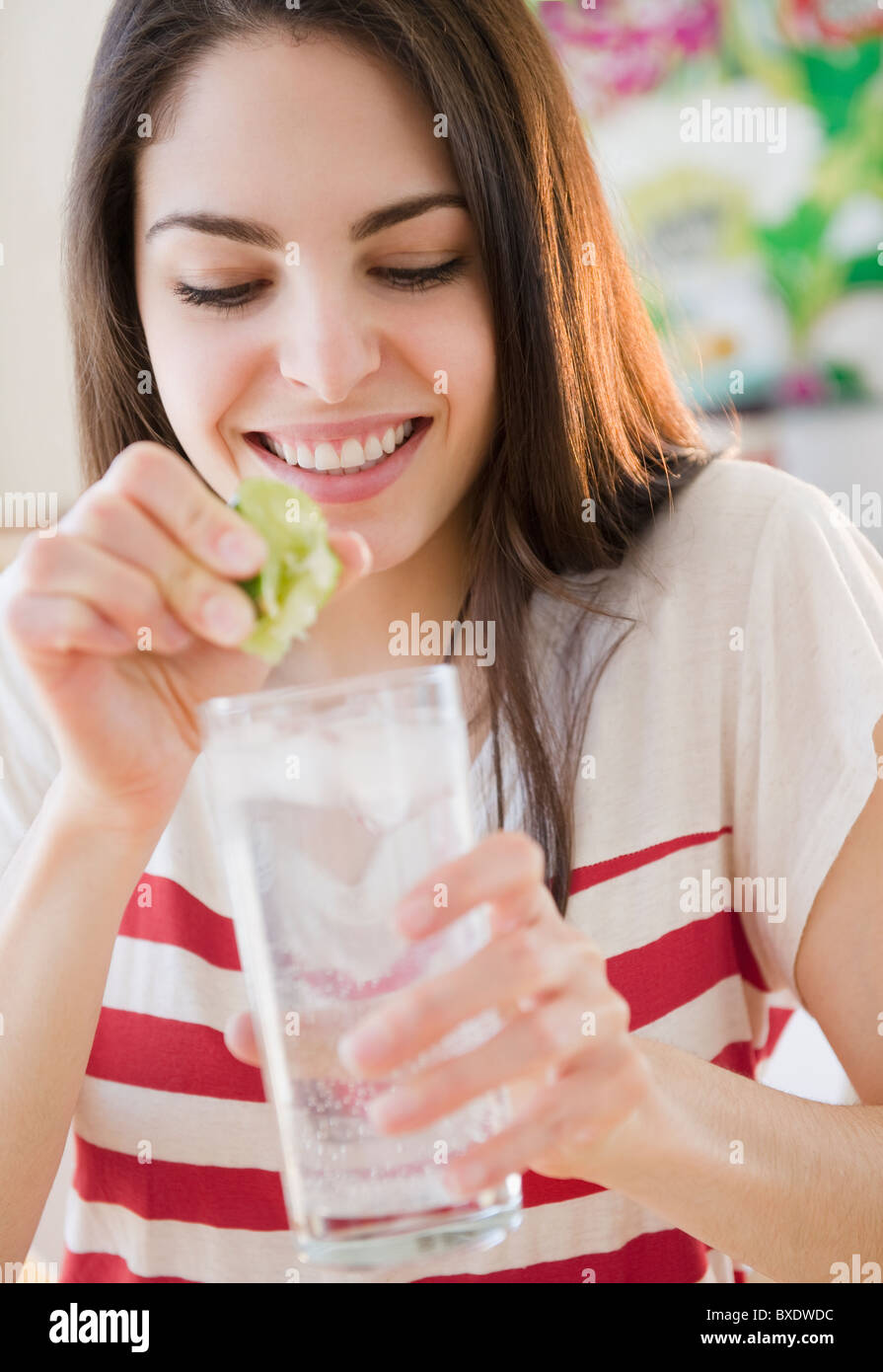 Woman squeezing lime into water Stock Photo - Alamy