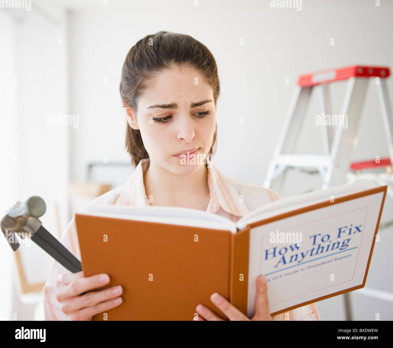 Confused woman reading do it yourself book Stock Photo - Alamy