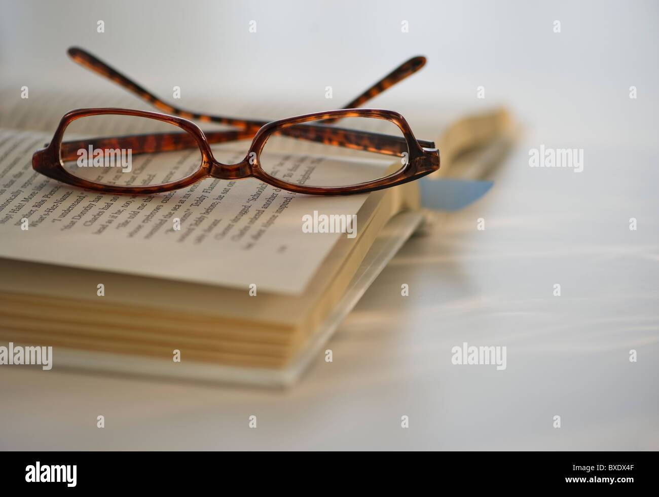 Reading glasses on book Stock Photo - Alamy