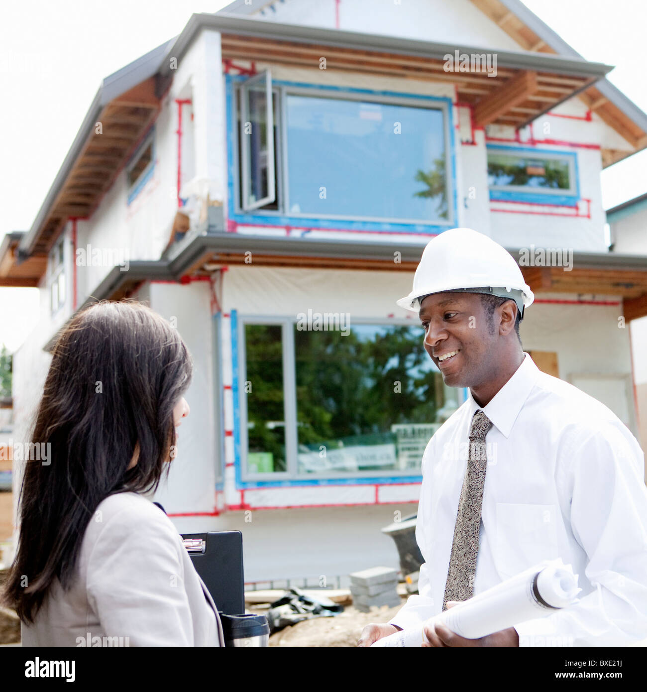 Real estate agents near house under construction Stock Photo - Alamy