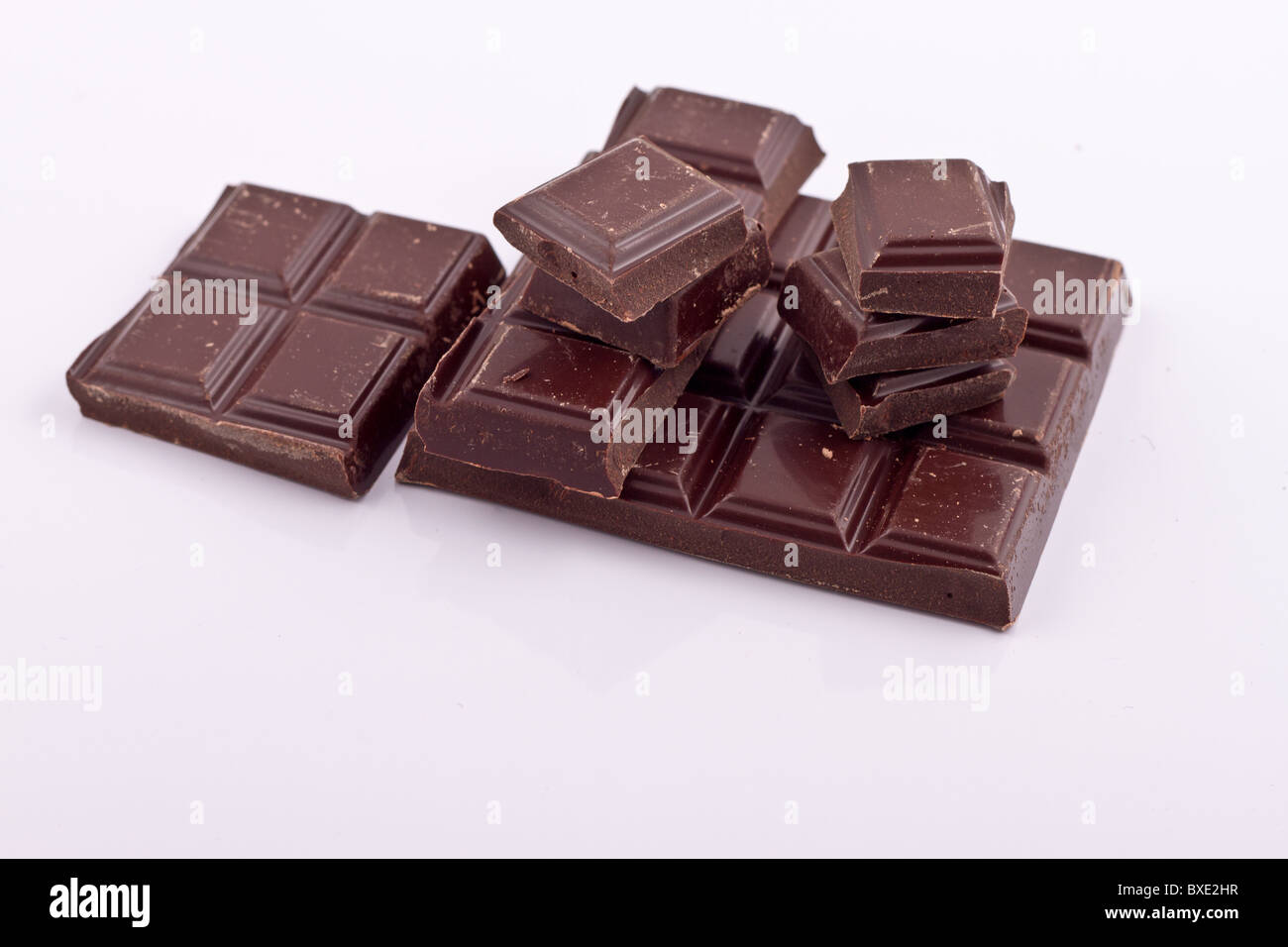 Stacked chocolate pieces on white background Stock Photo - Alamy