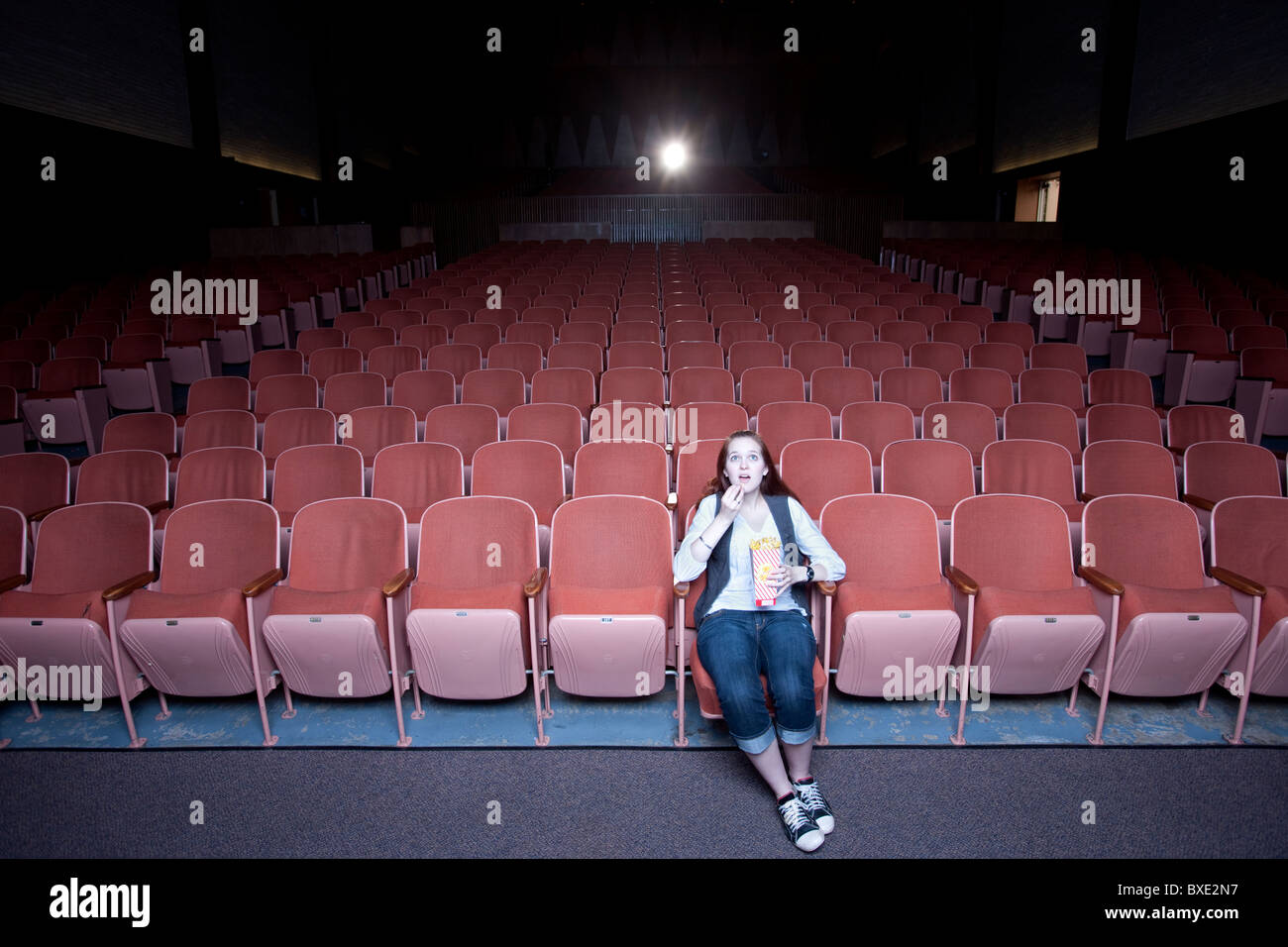 Caucasian woman watching move in empty theater Stock Photo - Alamy