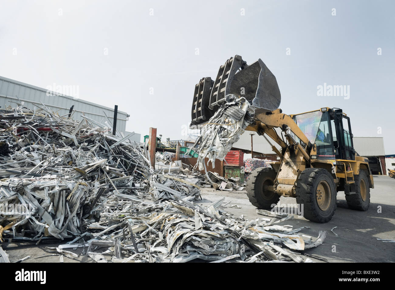 Backhoe dumping recyclable metal Stock Photo - Alamy