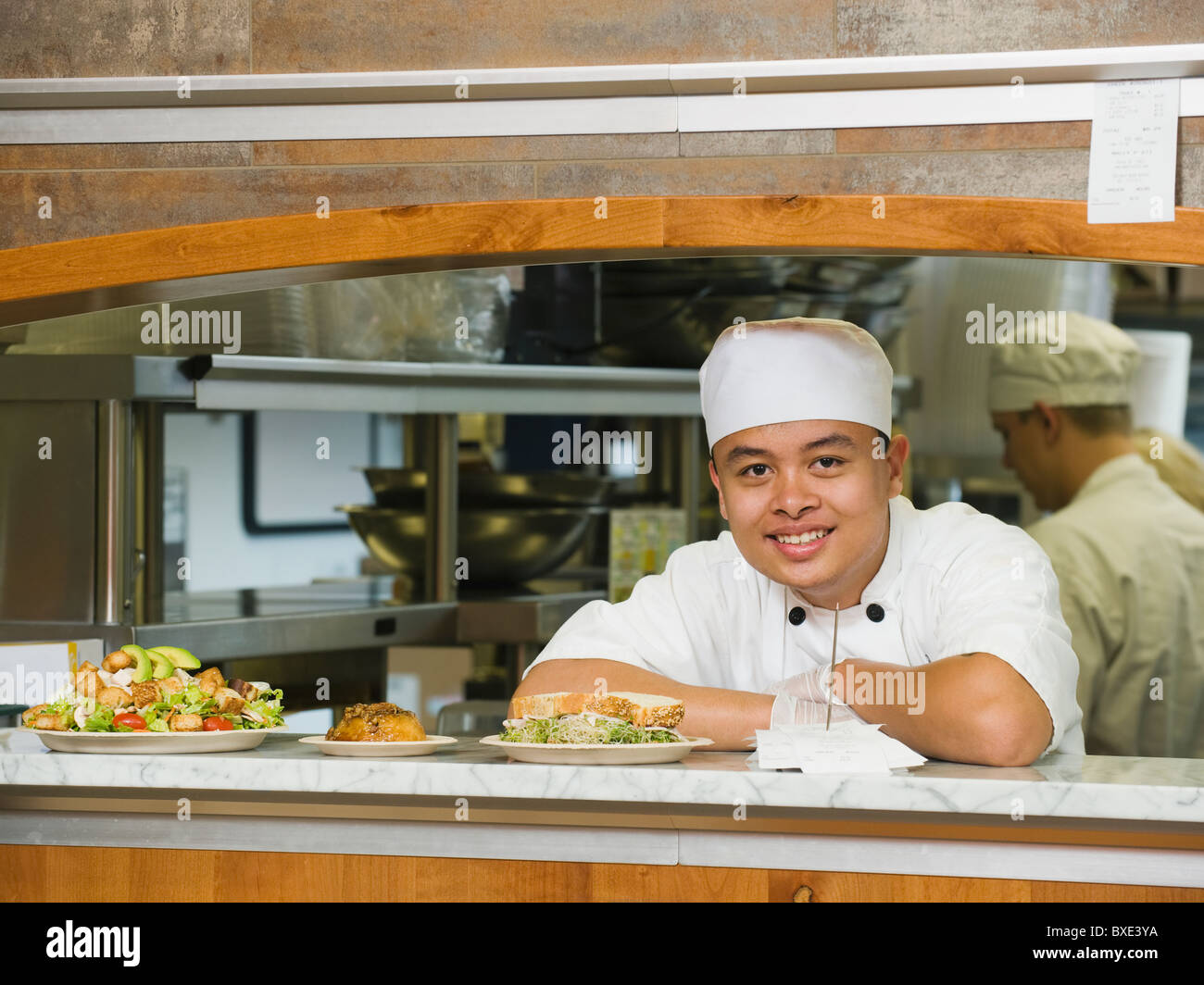 Chef leaning on counter Stock Photo - Alamy