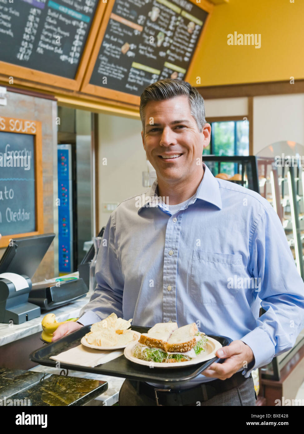 Man carrying sandwich on tray Stock Photo - Alamy