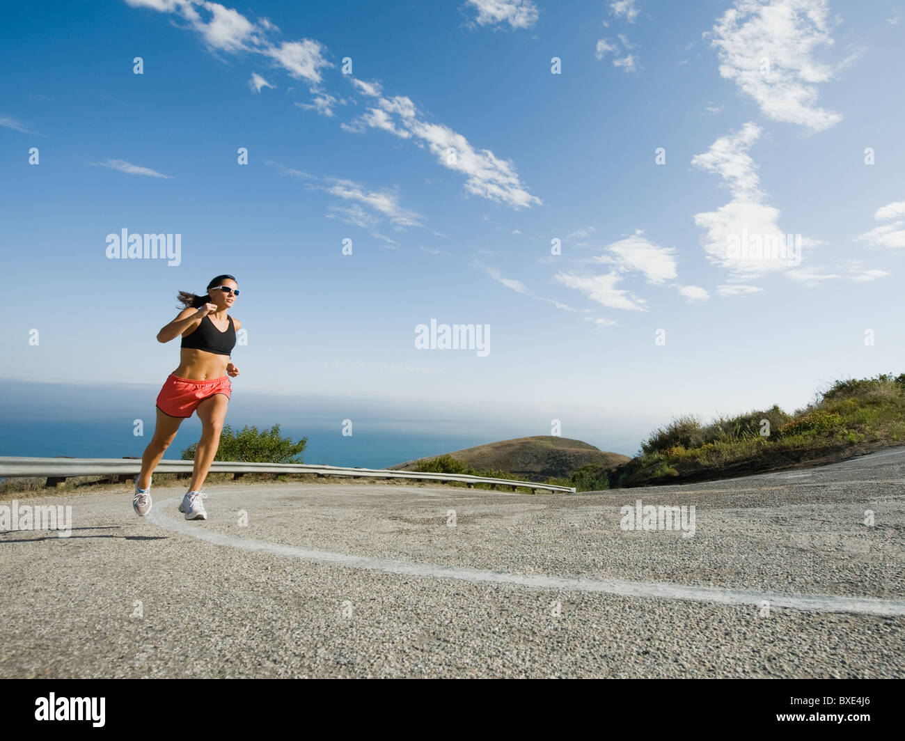Woman running on a road in Malibu Stock Photo - Alamy