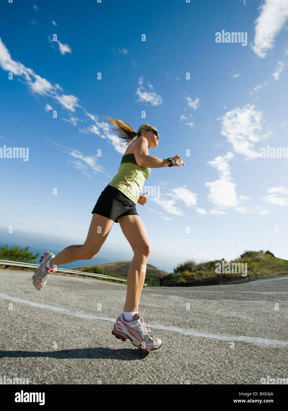 Woman running on a road in Malibu Stock Photo - Alamy