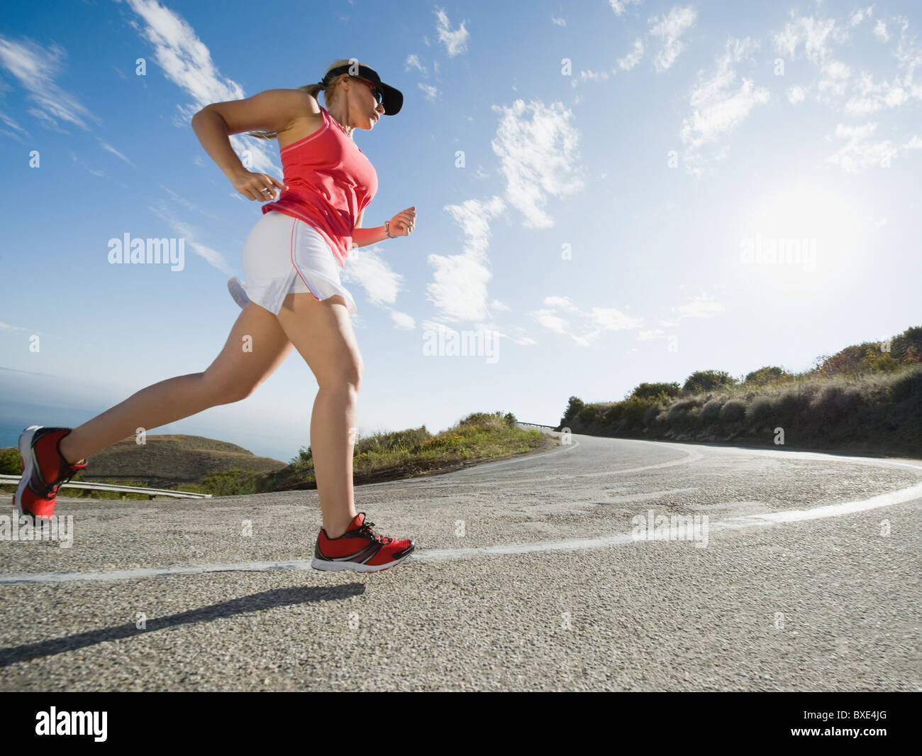 Woman running on a road in Malibu Stock Photo - Alamy