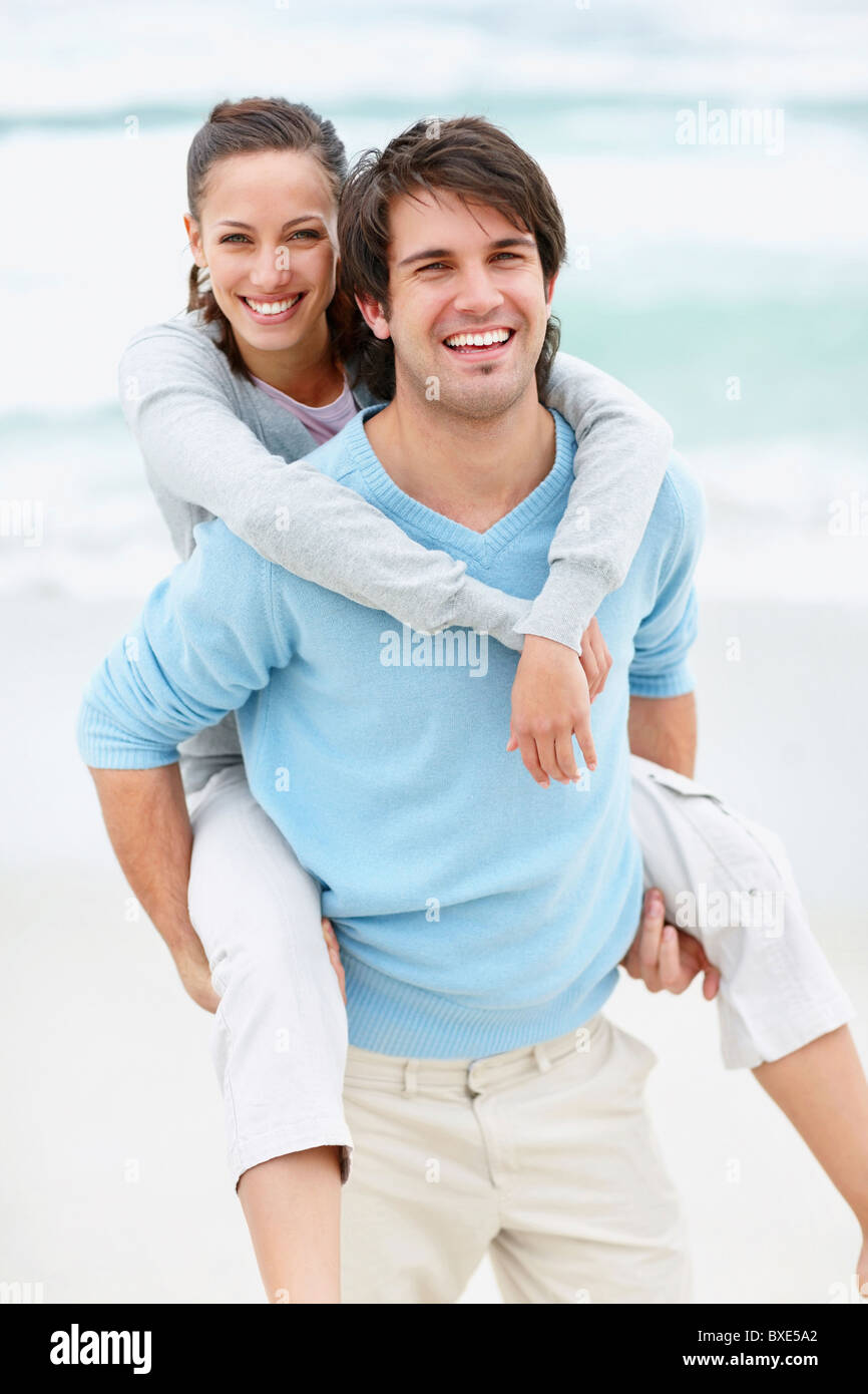 Man giving woman a piggy back ride Stock Photo - Alamy