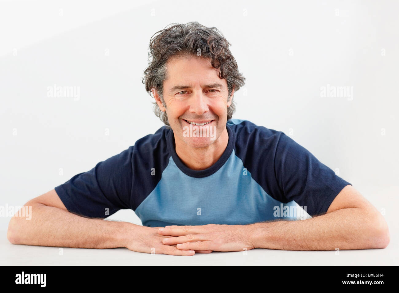 Handsome man sitting at table Stock Photo - Alamy