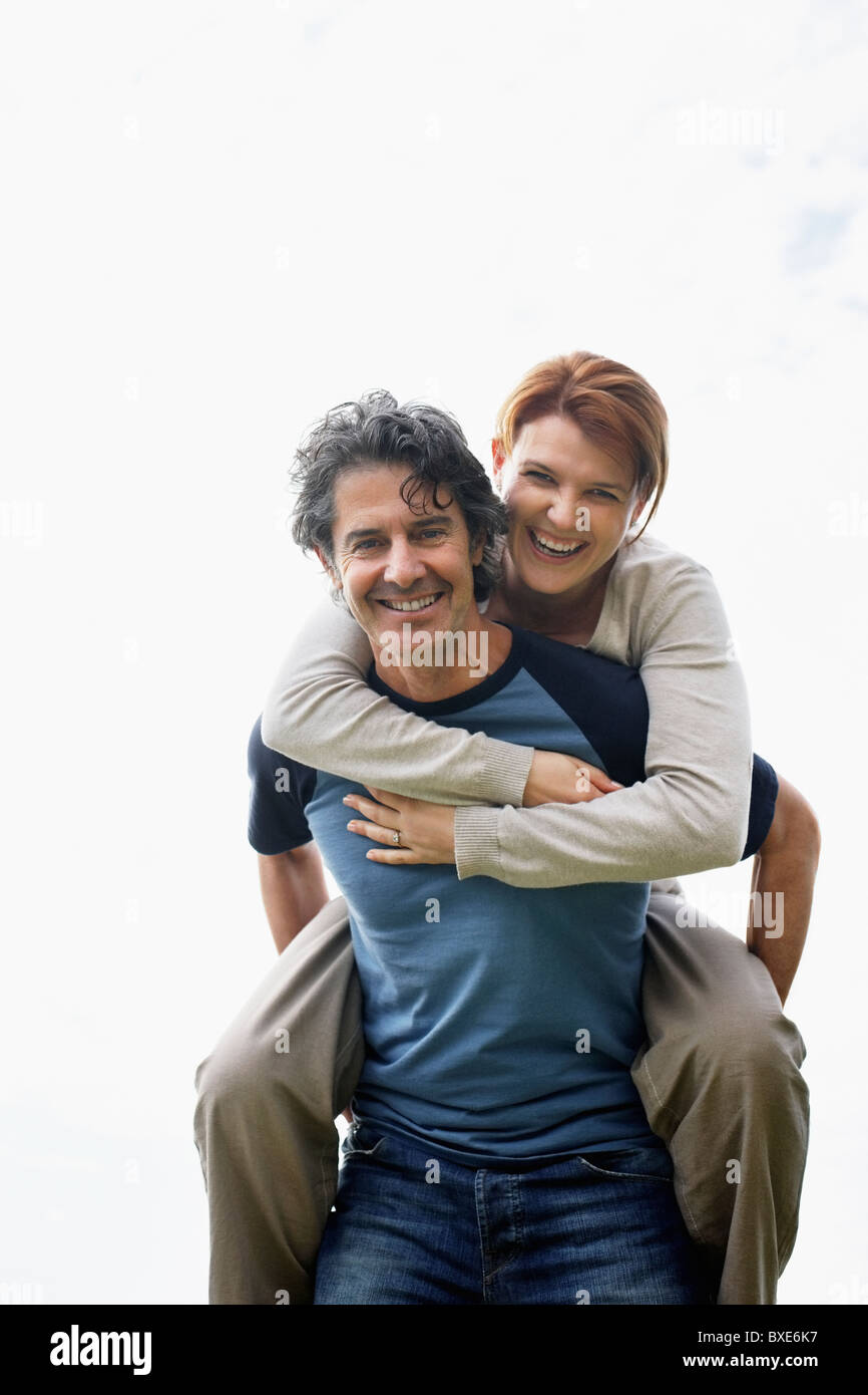 Man giving woman a piggy back ride Stock Photo - Alamy