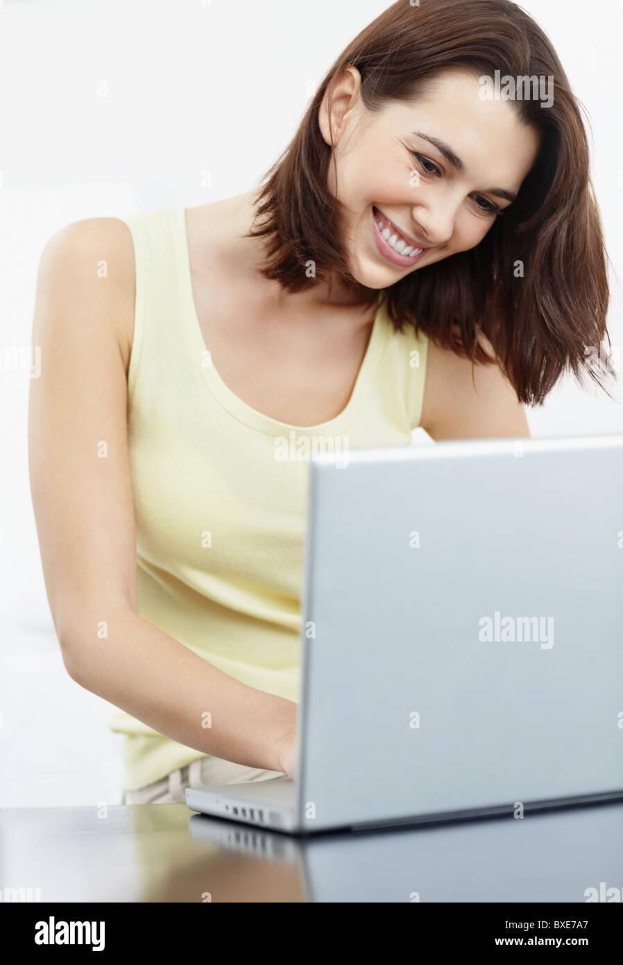 Smiling brunette woman browsing the internet Stock Photo - Alamy