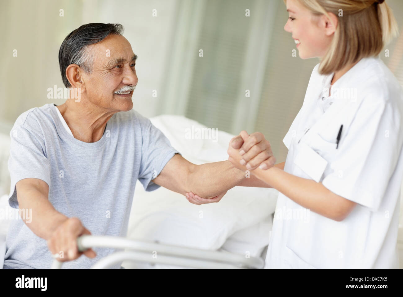Nurse assisting patient with a walker Stock Photo - Alamy