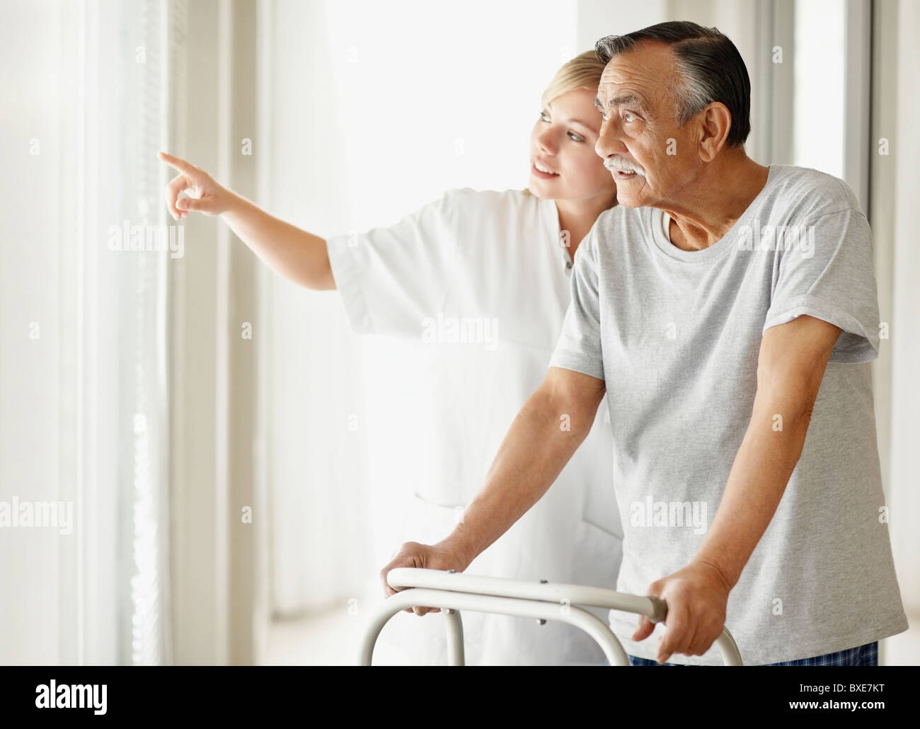 Nurse assisting patient with a walker Stock Photo - Alamy