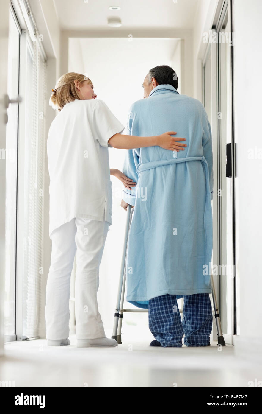 Nurse assisting patient with a walker Stock Photo - Alamy
