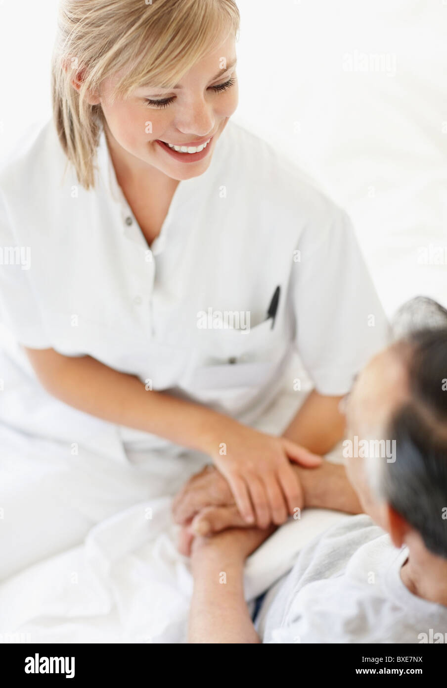 Nurse sitting with patient Stock Photo - Alamy