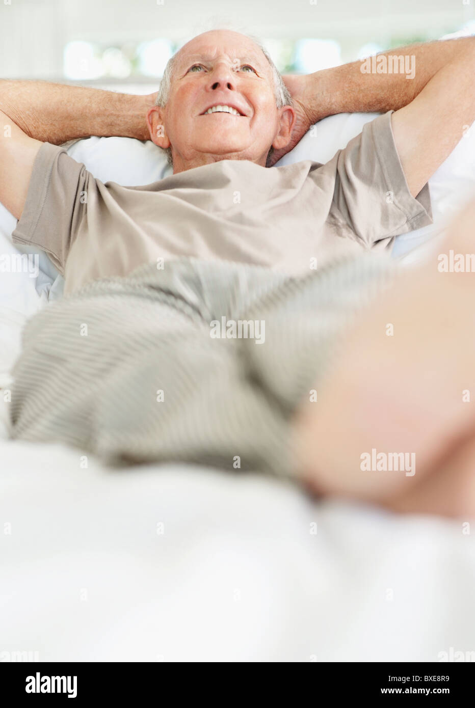 Relaxed senior man lying on bed Stock Photo - Alamy