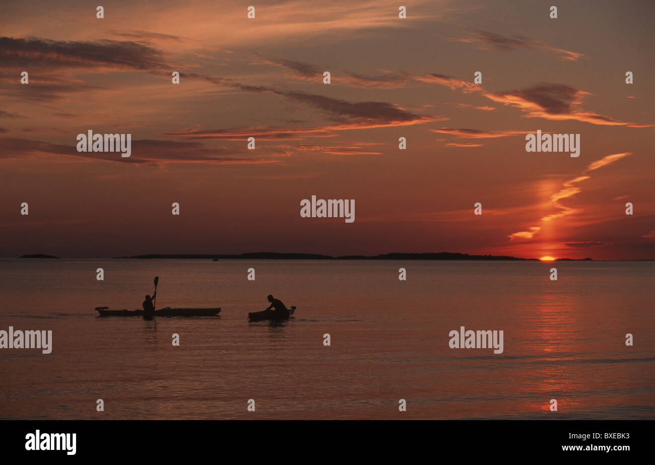 Kayaking in a red sunset, still water, red water and skies, people and ...