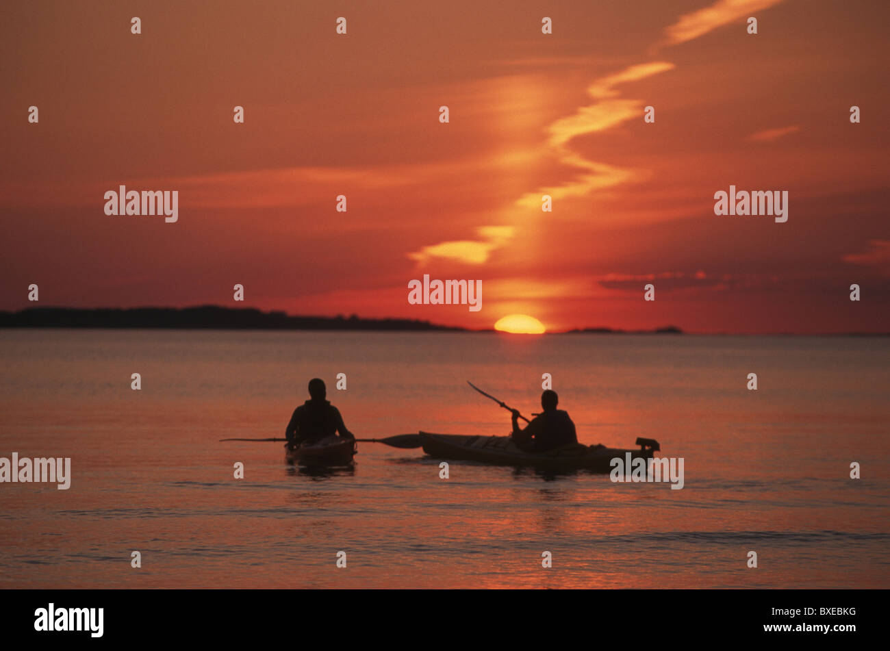 Kayaking in a red sunset, still water, red water and skies, people and ...