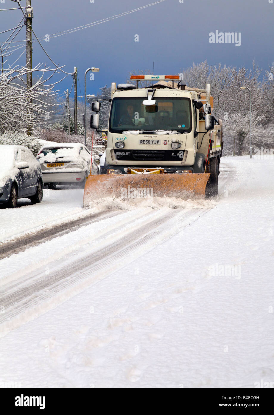 UK County Council snow plough lorry clearing snow on minor road Stock ...