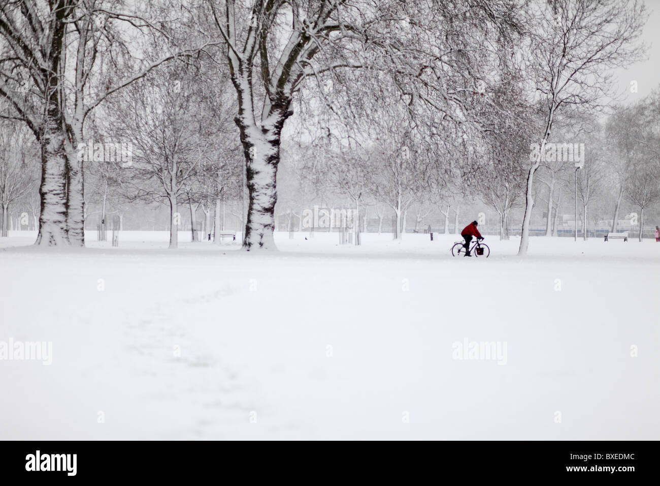 in distance cyclist riding bike on snow Stock Photo - Alamy