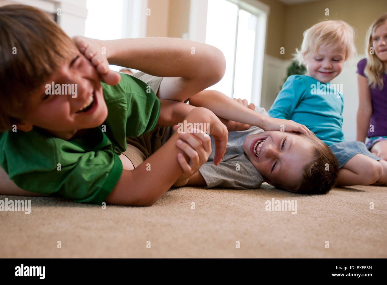 Children play fighting on floor Stock Photo - Alamy
