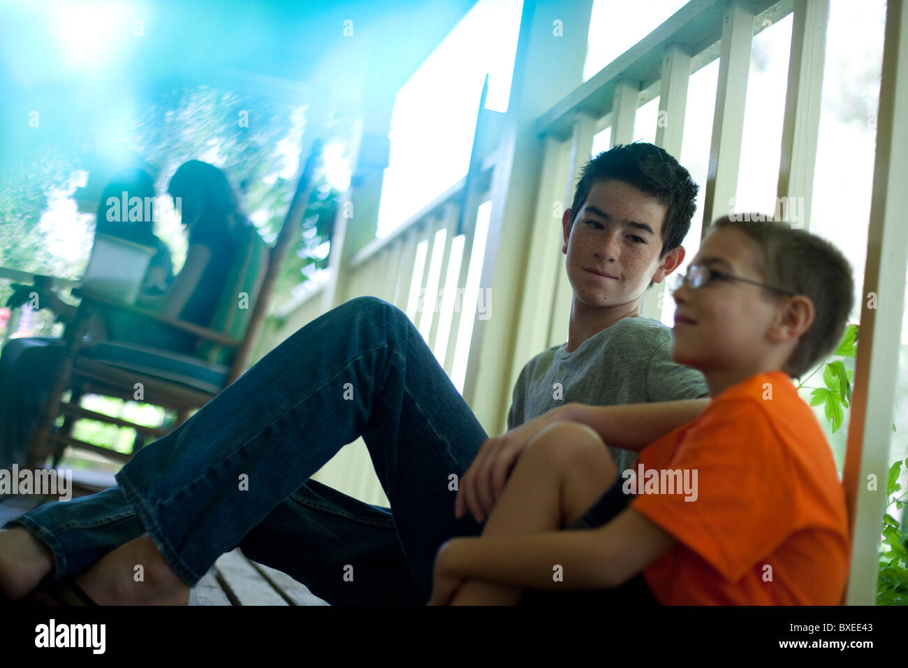 Two young boys sitting on porch Stock Photo - Alamy