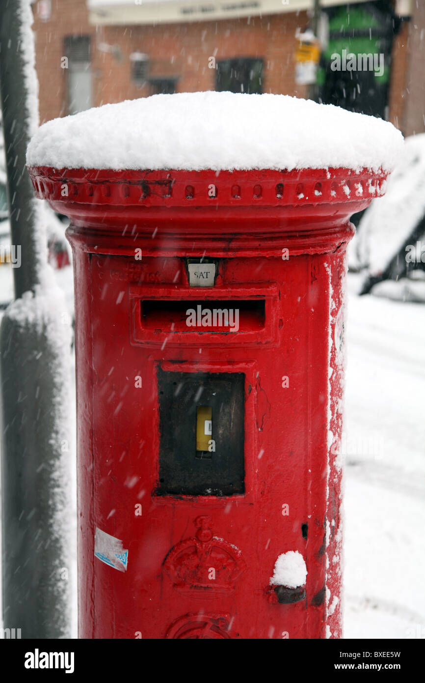 A red letterbox being snowed on. Putney High Street. London Stock Photo ...