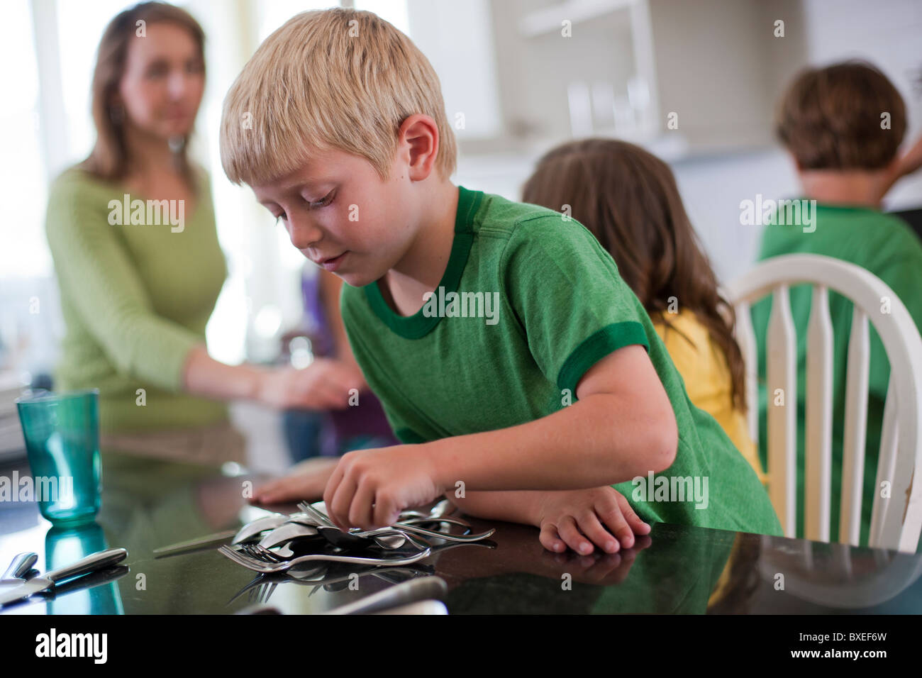 Young boy setting the table Stock Photo - Alamy