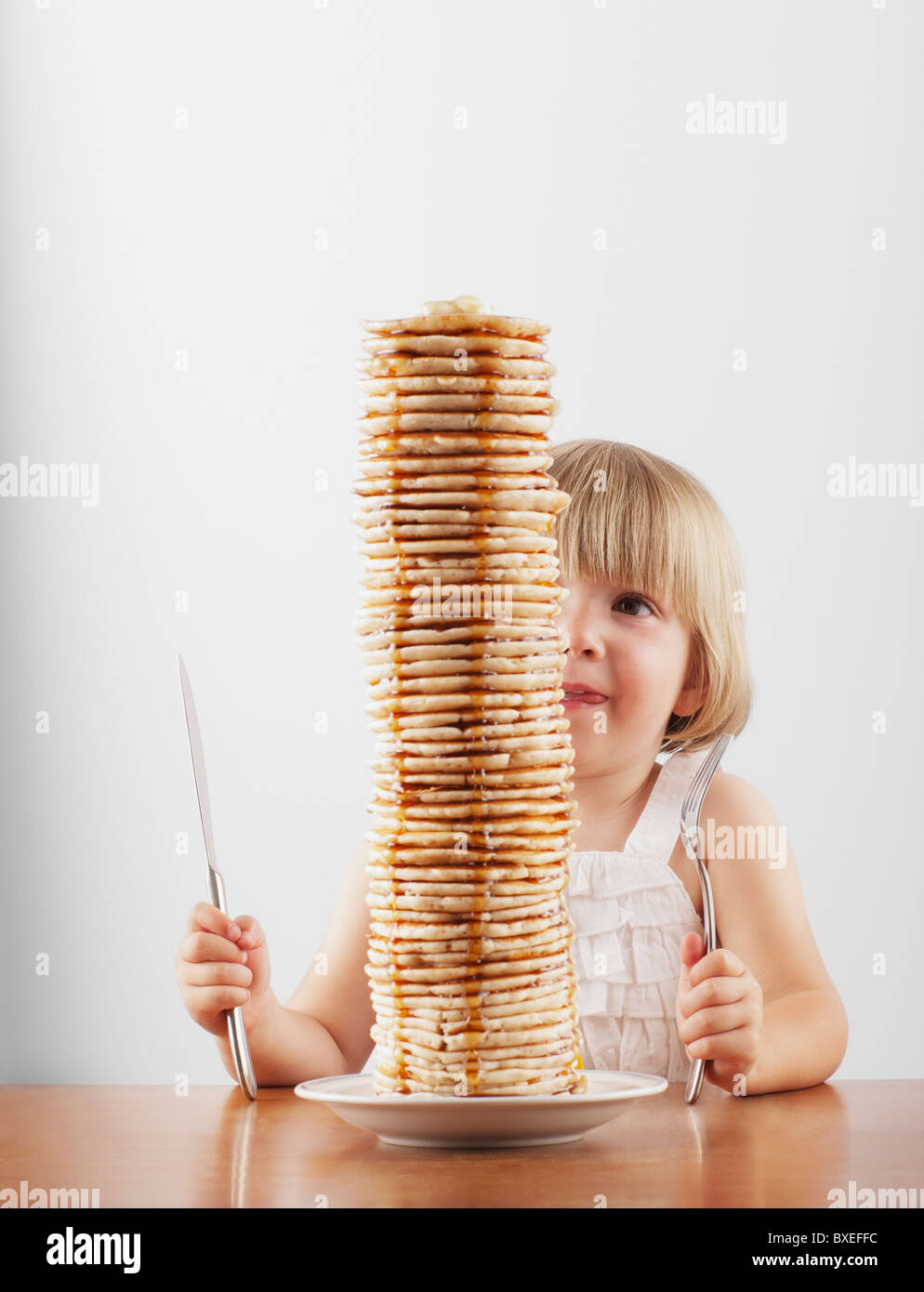 Young girl sitting behind a tall stack of pancakes Stock Photo - Alamy
