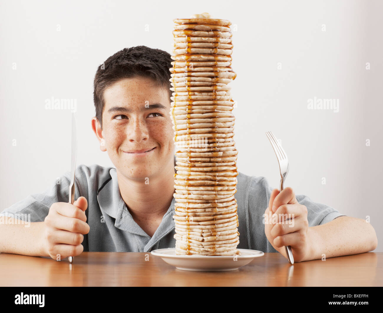 Young boy sitting behind a tall stack of pancakes Stock Photo - Alamy