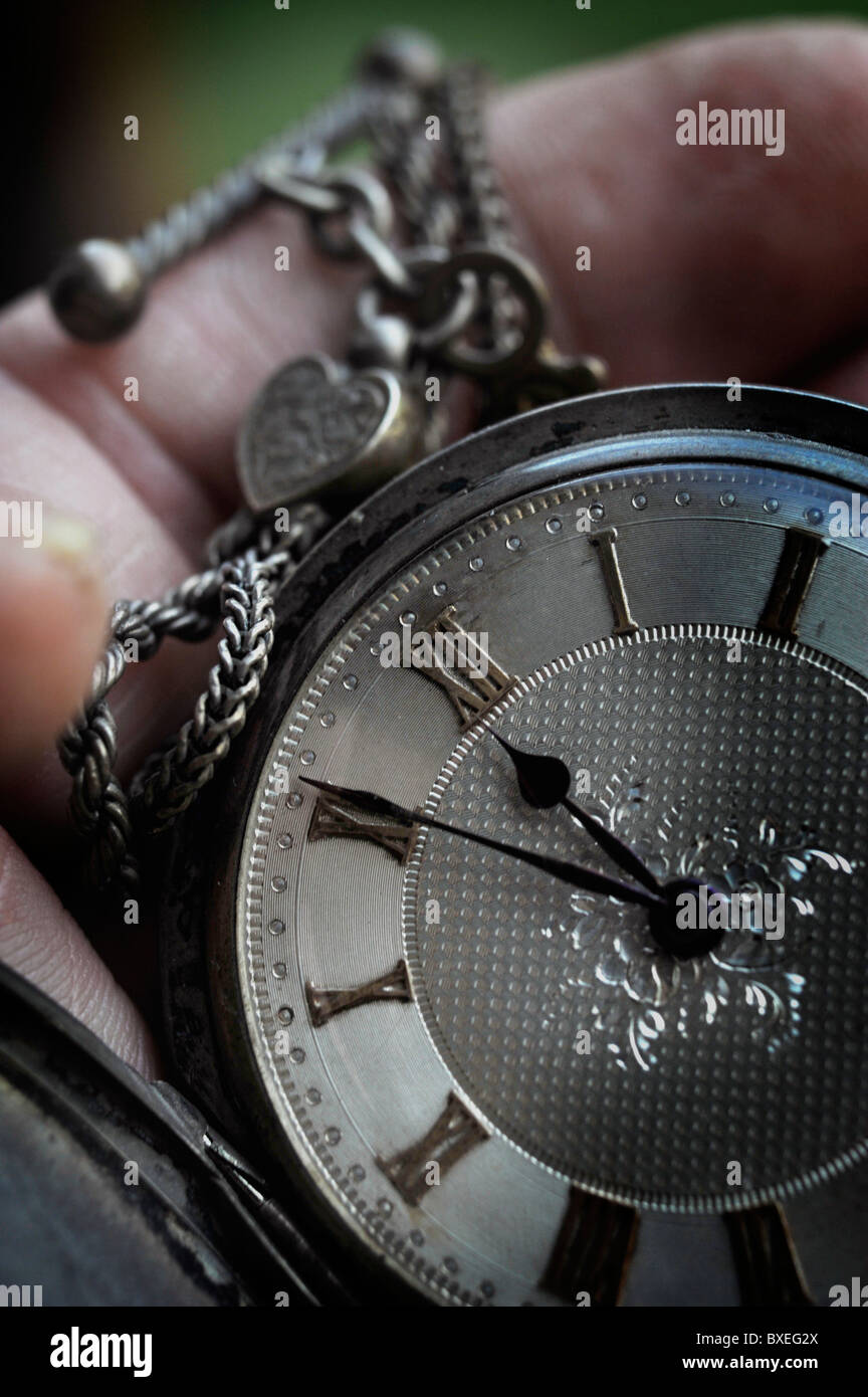 hand holding antique silver pocket watch with hands at ''five to twelve ...