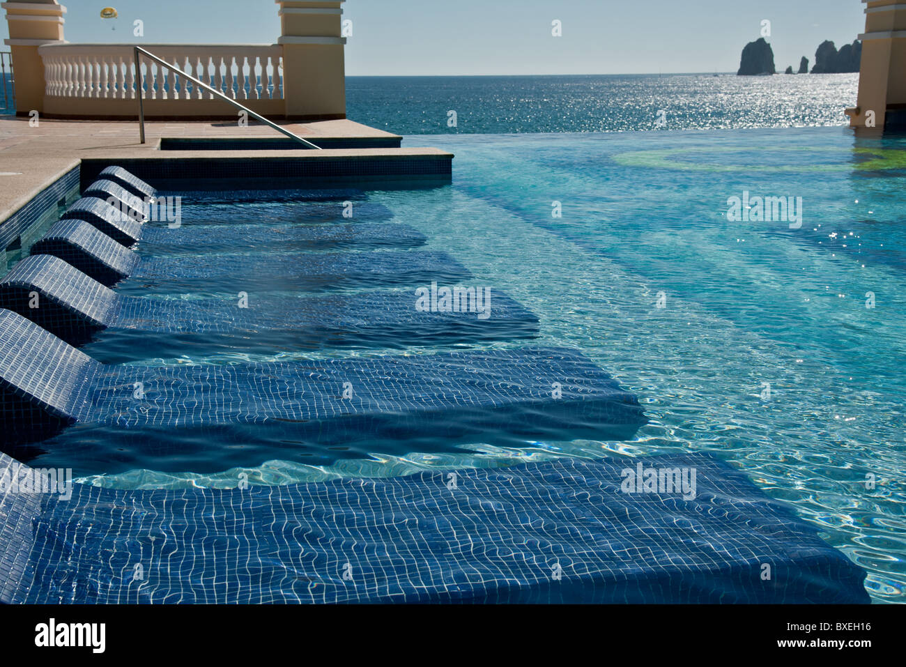 A swimming pool merges into tropical ocean at a resort in Mexico Stock ...