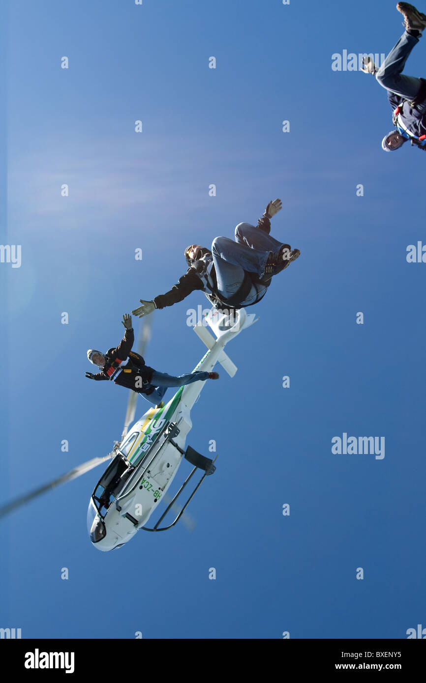 Skydivers are jumping out of a helicopter in the blue sky with over 120 ...