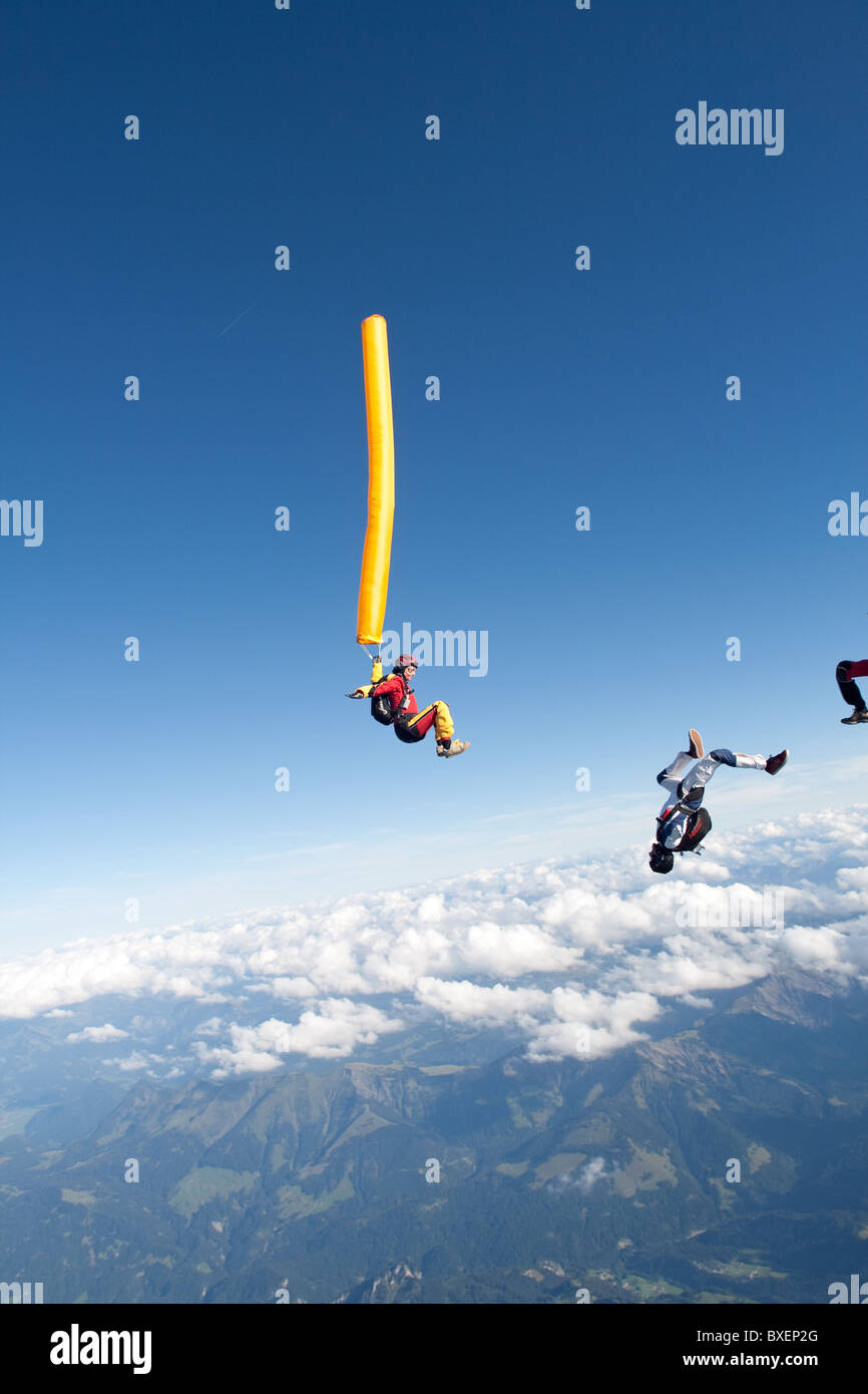 Skydiver with orange air tube and friends are falling through the sky ...