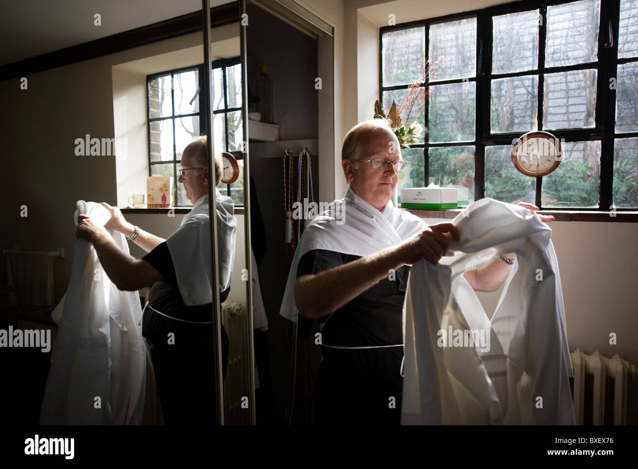 Priest puts on his Alb before morning Mass in Sacristy (Vestry) at St ...
