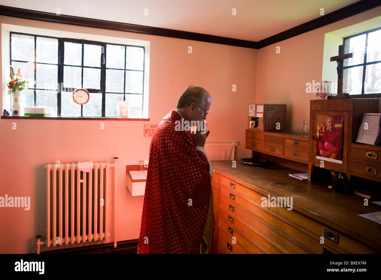 Priest says brief prayer in backroom Sacristy (Vestry) before Mass at ...