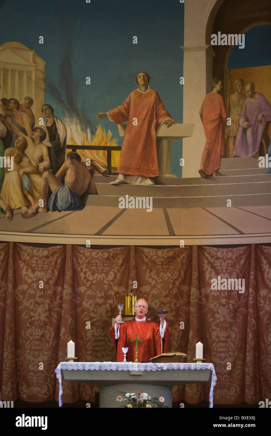 Priest raises chalice and paten during Liturgy of the Eucharist Mass at ...