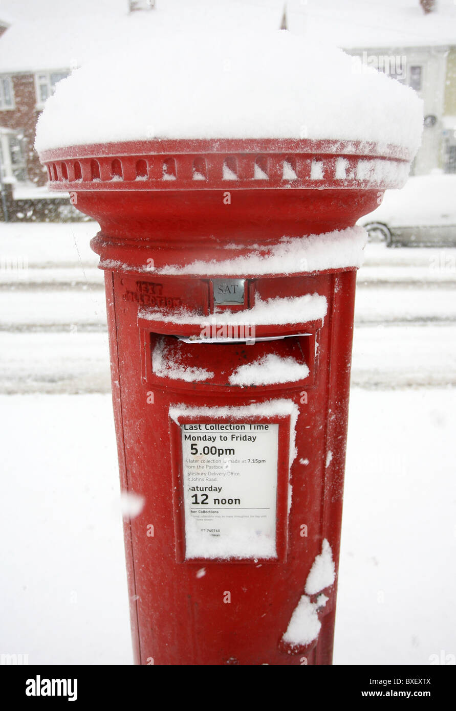 A red british post box overflowing with mail covered in snow Stock ...