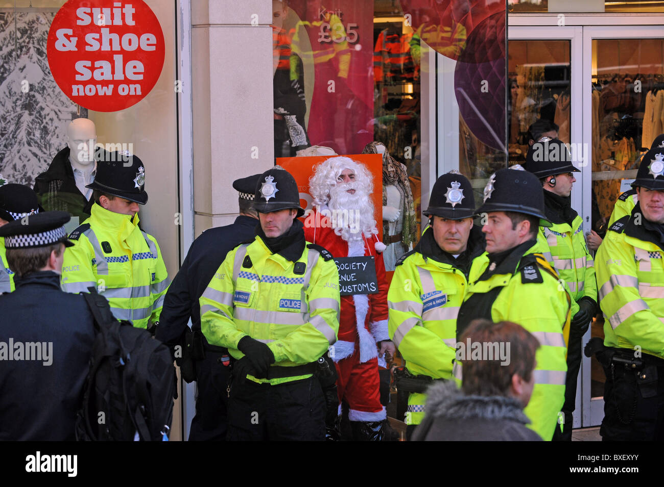 Police surround a demonstrator dressed as Santa who had glued himself ...
