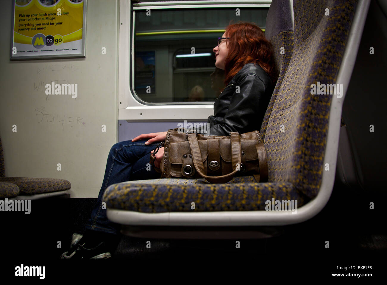 Young woman sat on a train Stock Photo - Alamy