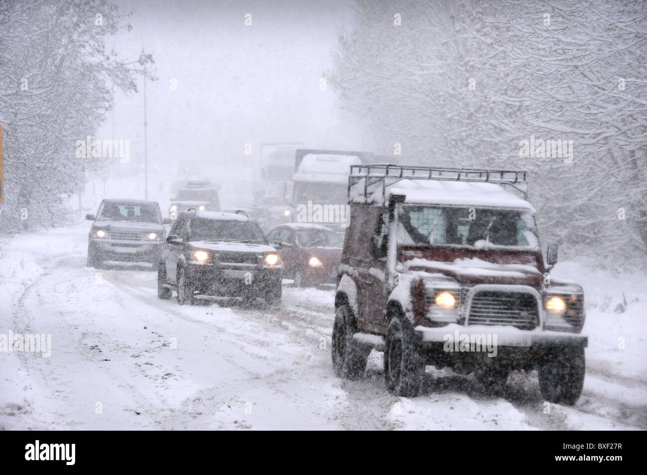 A Land Rover Defender and other four wheel drive vehicles past stranded ...