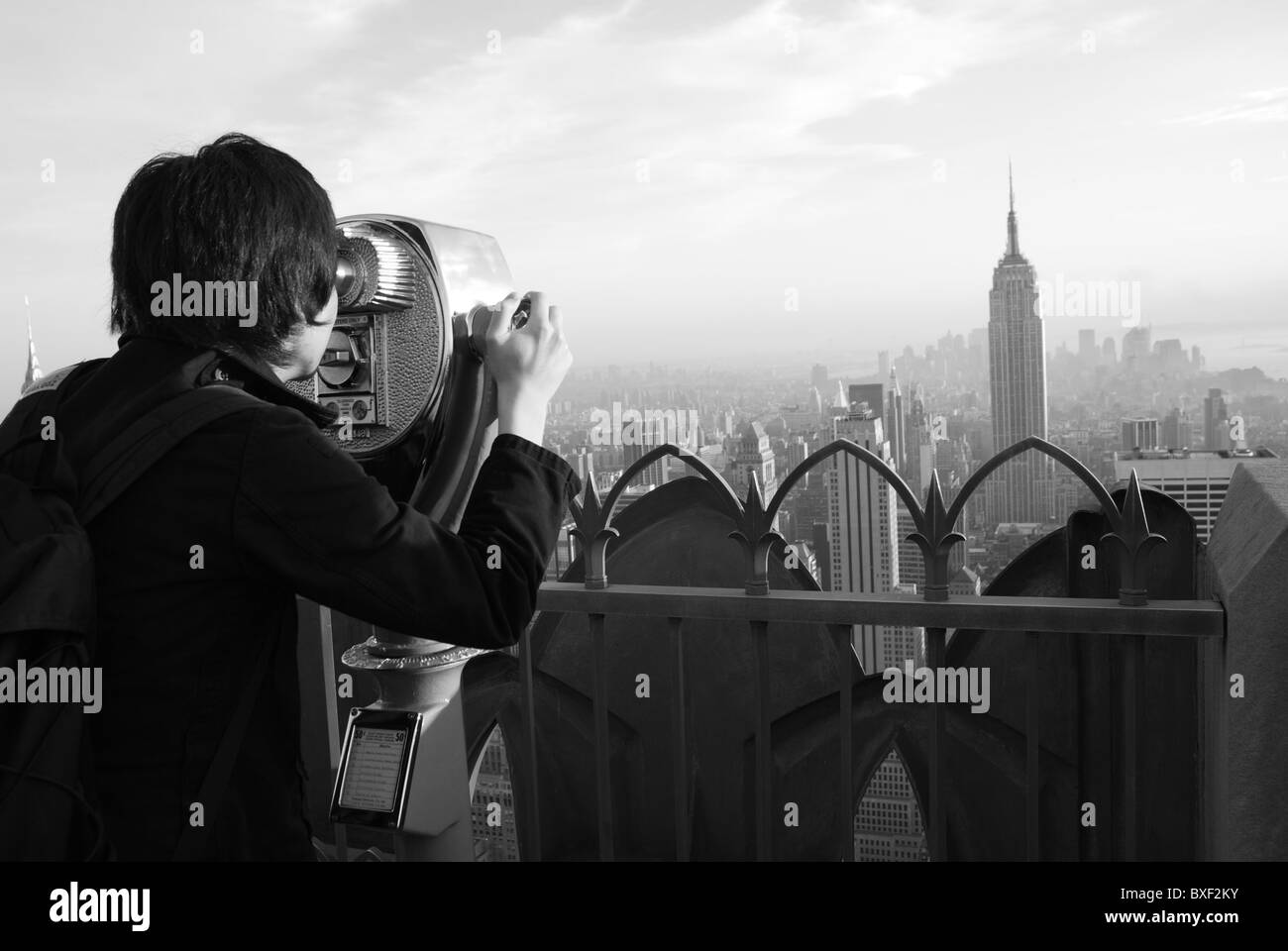 A man looks through a telescope from Rockefeller Center in lower ...